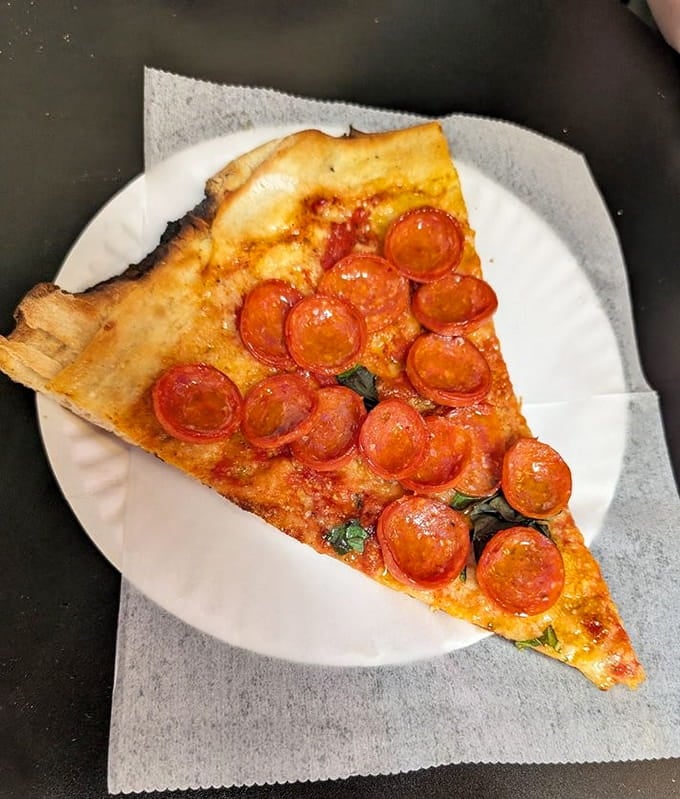 Pepperoni circles glisten like edible jewels, each one a tiny disc of spicy, greasy, absolutely glorious perfection.