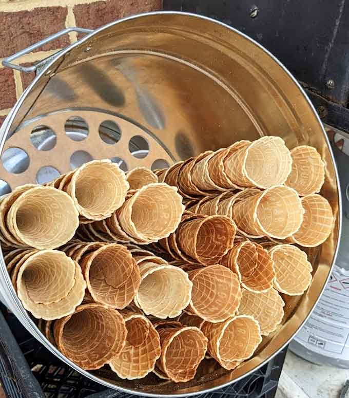 Fresh waffle cones stacked like edible architecture, each one a crispy golden masterpiece waiting to happen.