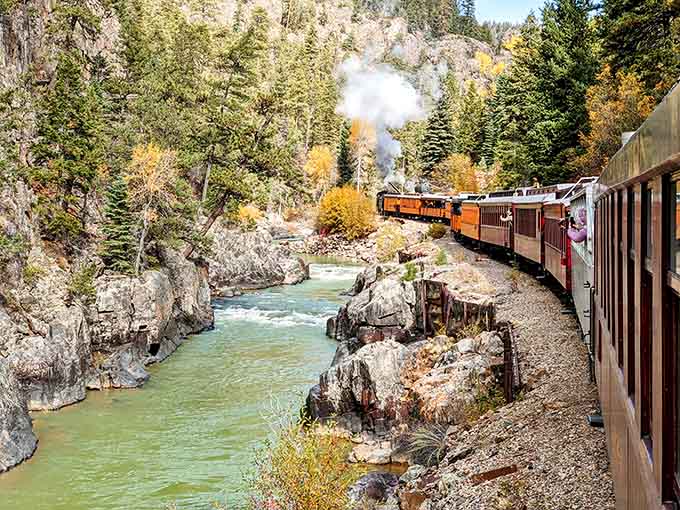 Fall colors frame the journey as the Animas River rushes alongside, nature's perfect travel companion.