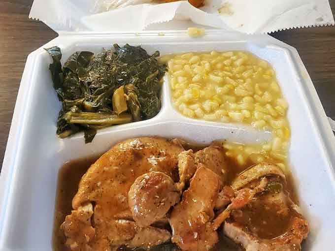 Pork chops swimming in gravy with corn and greens, proving that some meals are worth loosening your belt for.