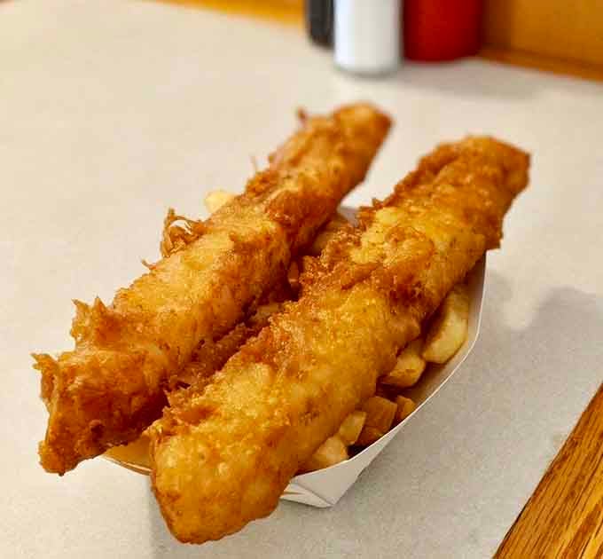 Golden perfection on display&mdash;two pieces of cod in crispy batter resting atop a bed of chips, a duo that's been making taste buds dance since before The Beatles.