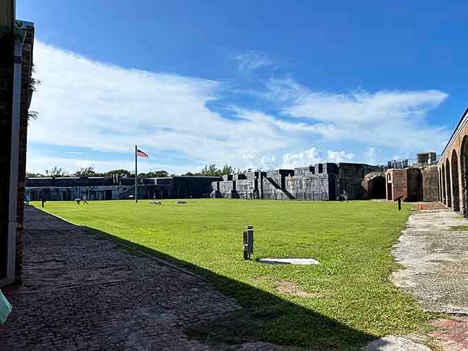 The parade ground looks peaceful now, though visitors swear the atmosphere changes once you step inside those brick corridors and archways.