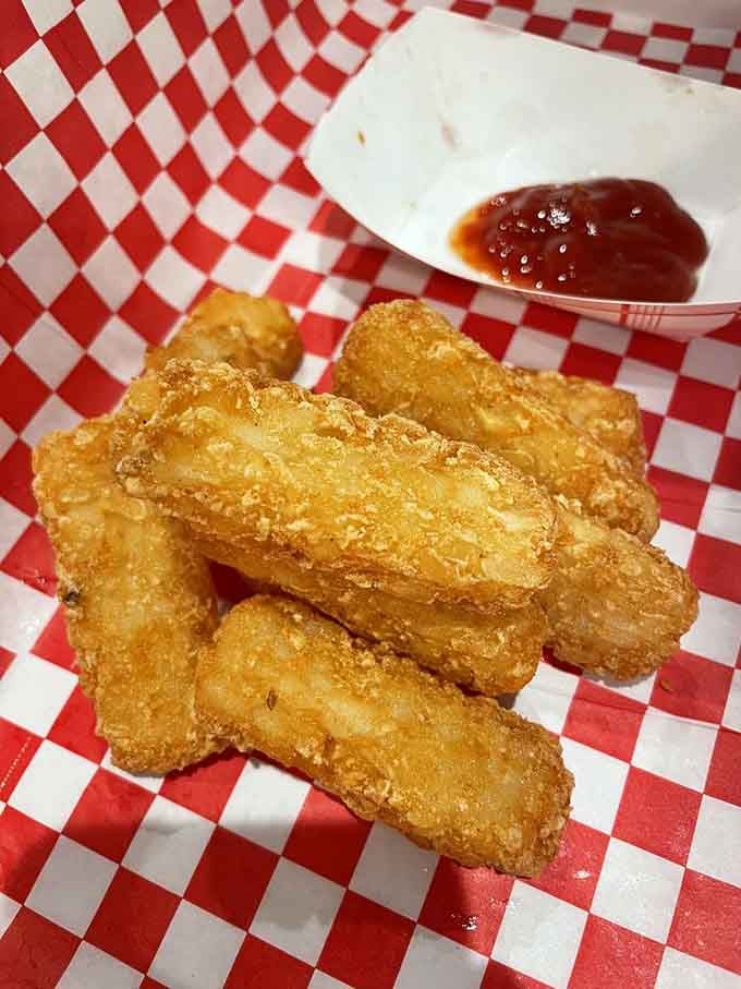Golden, crispy tater ties arrive like edible railroad spikes, perfect for dipping and absolutely worth the inevitable ketchup negotiations.