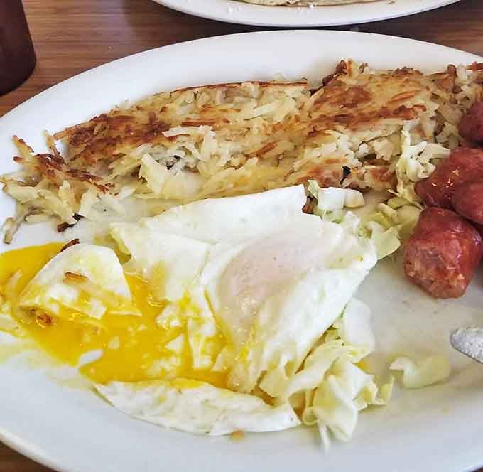 Breakfast architecture at its finest &ndash; golden hash browns supporting sunny eggs and Portuguese sausage in a delicious construction project that puts your hunger to rest.