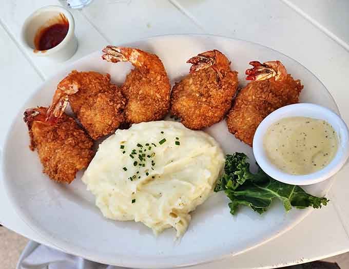Golden coconut shrimp that's hand-dipped and fried to crispy perfection with creamy mashed potatoes alongside.