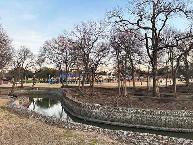 A peaceful stream winds through the park, proving nature and modern play equipment make surprisingly good neighbors together.