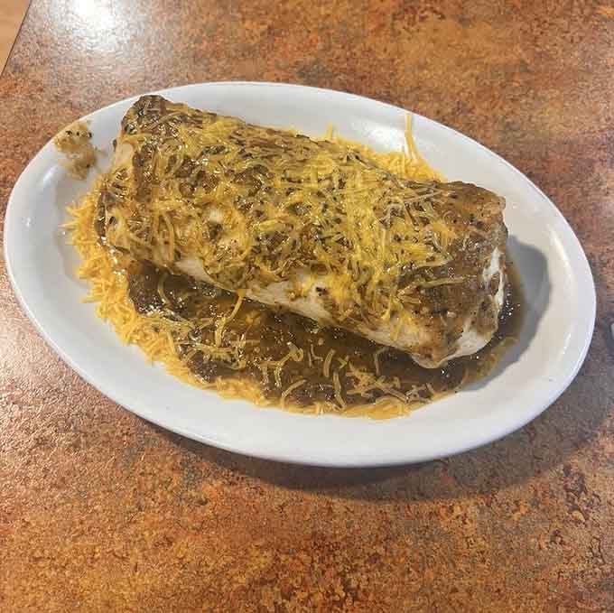 Behold the breakfast burrito that earned Food Network fame, smothered in green chili and melted cheese perfection.