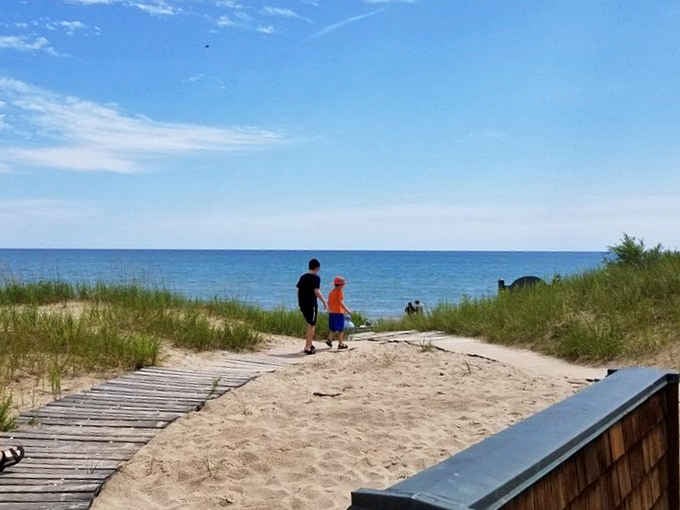 The wooden walkway leads eager beachgoers toward that first magical glimpse of the sparkling water ahead.