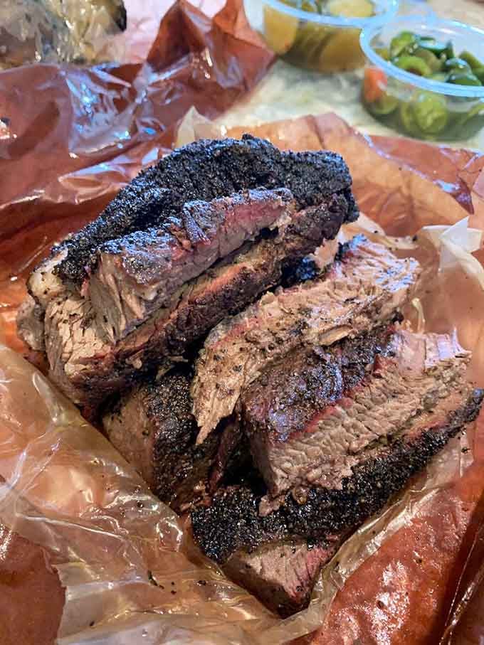 Behold the brisket in all its glory, with that dark bark and pink smoke ring that dreams are made of.