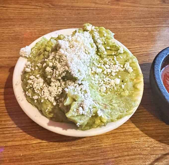 Fresh guacamole topped with cotija cheese and peanuts, because sometimes tradition comes with delightful unexpected twists.