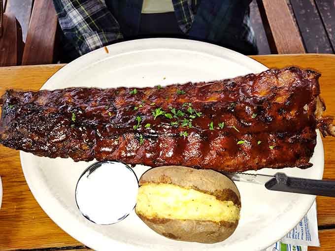 A full rack of ribs that could make a vegetarian reconsider their life choices, served with a perfectly baked potato.