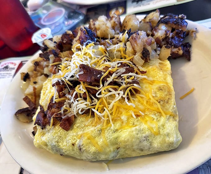 Behold the omelet of champions! Perfectly folded egg blanket cradling a treasure trove of fillings, with home fries standing guard on the perimeter.