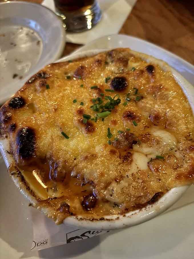 Behold the French onion soup in all its glory&mdash;a bubbling cauldron of caramelized goodness beneath a golden canopy of cheese that stretches like a dairy dreamscape.