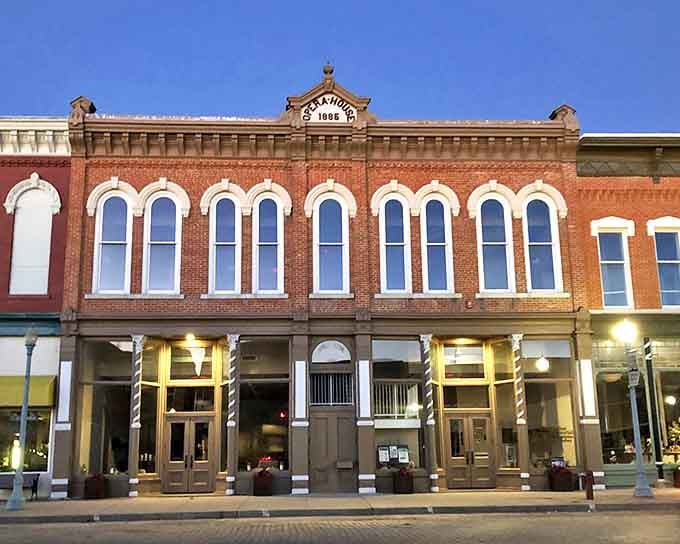 The Opera House glows at dusk, its ornate brick fa&ccedil;ade and arched windows hinting at cultural evenings that have delighted Red Cloud residents for over a century.