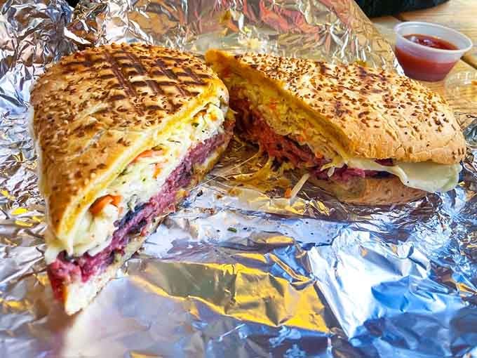 Behold the pastrami on sesame-studded bread, a towering achievement in sandwich engineering that defies gravity and common sense.