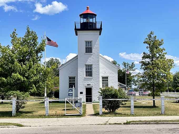 The Sand Point Lighthouse stands crisp against summer skies, a postcard-perfect sentinel that's been guiding ships and tourist photos since 1868.