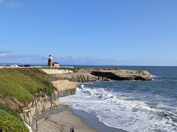 The lighthouse at Lighthouse Point watches over surfers like a patient parent at a playground.