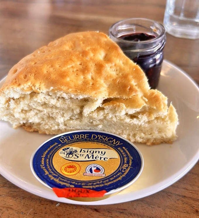 McKay Cottage's famous scone, perfectly golden and fluffy, served with premium butter and house-made berry jam. A breakfast dream!
