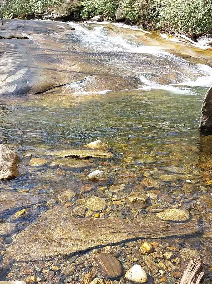 Crystal-clear mountain water reveals every smooth contour of this 60-foot natural slide carved by time itself.