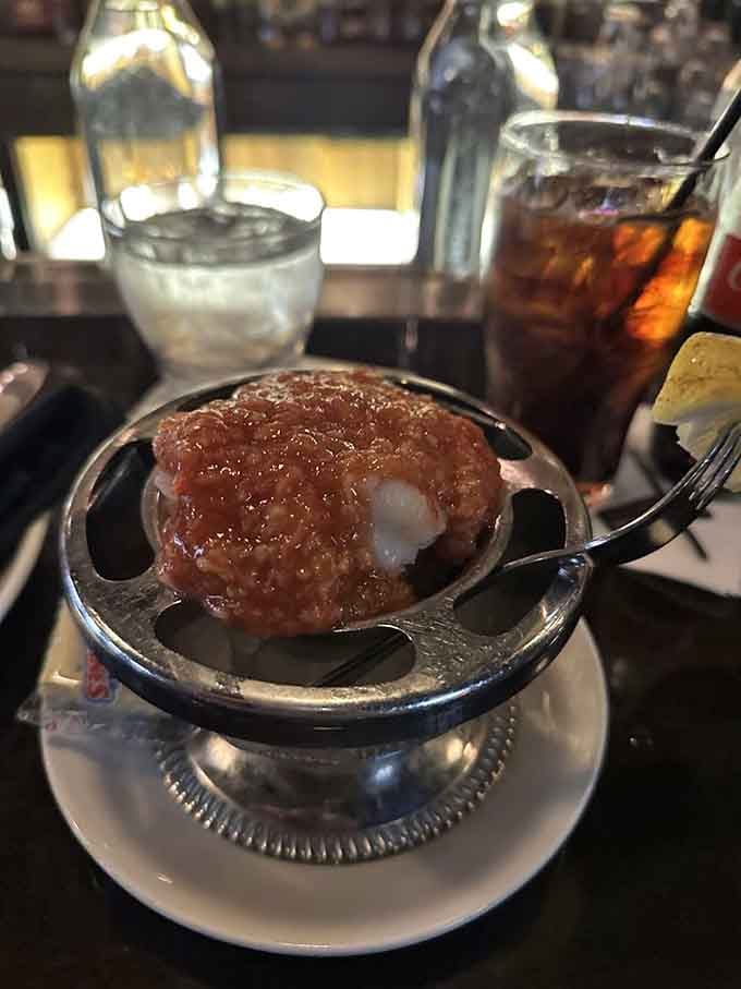 One innocent-looking shrimp perched over cocktail sauce that's about to rearrange your entire sinus system in the best way.