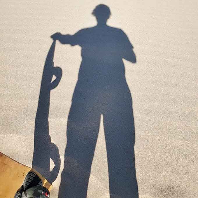 Your shadow becomes art on the pristine sand, though your legs will feel less poetic after the climb.