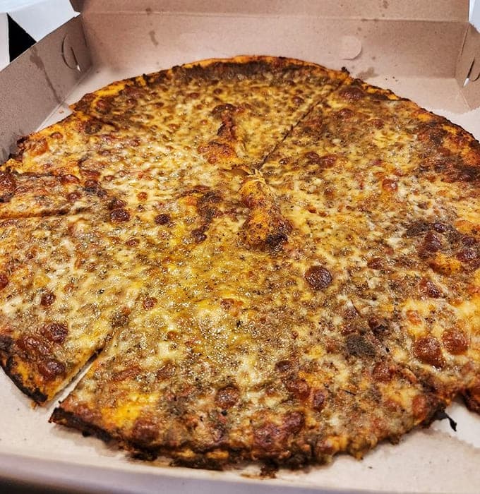 The pesto pizza brings herbaceous joy to that legendary thin crust, proving green can be gorgeous and delicious.