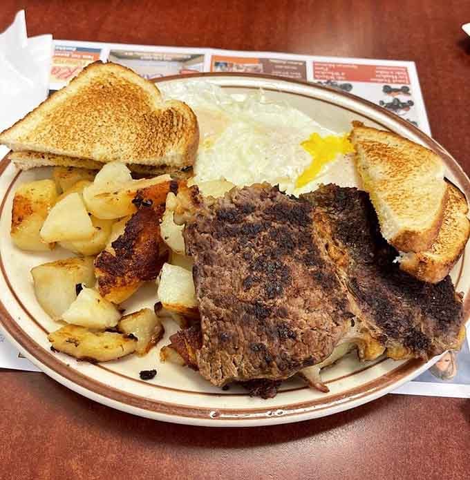 Behold the breakfast of champions: a steak cooked just right, eggs sunny-side up, and home fries that could make a potato farmer weep with joy.