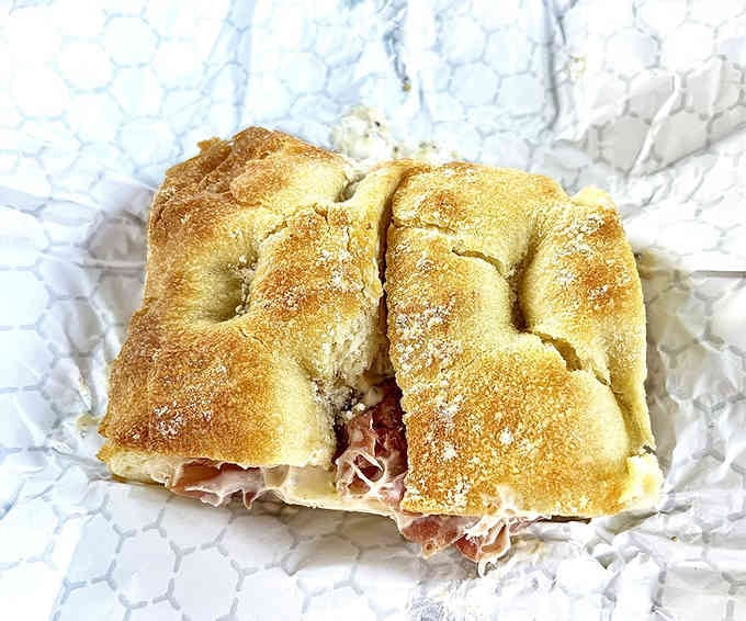 Golden focaccia cradling prosciutto and provolone, this sandwich looks like it belongs in an Italian dream sequence.