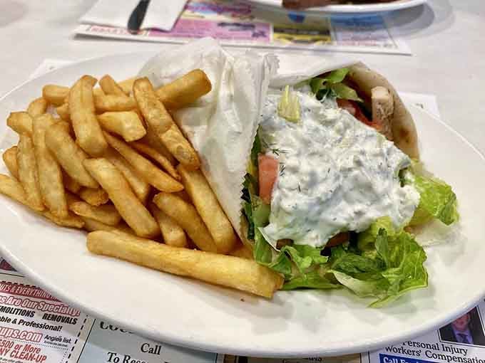 That chicken gyro comes loaded with enough toppings to require architectural planning before your first bite.