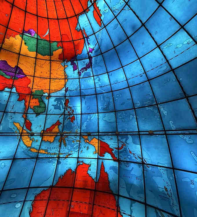 Looking up reveals the intricate detail of each glass panel, a kaleidoscope of continents that surrounds you completely.