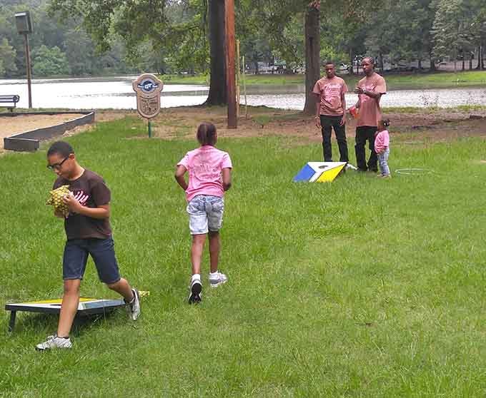 Family fun takes center stage as these cornhole competitors enjoy lakeside recreation. Sometimes the simplest games create the most lasting memories.
