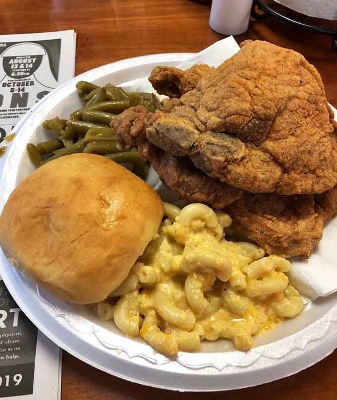 Golden fried chicken towering over mac and cheese that could make a grown person weep with joy.