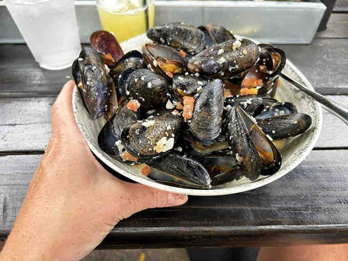 Fresh Prince Edward Island mussels swimming in white wine and garlic broth, begging for that garlic bread.
