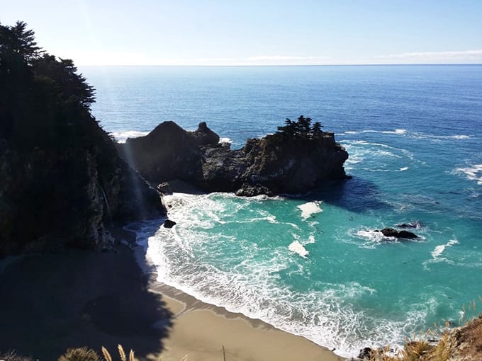 Mother Nature's private cove, where turquoise waters kiss golden sand while dramatic cliffs stand guard like protective parents.