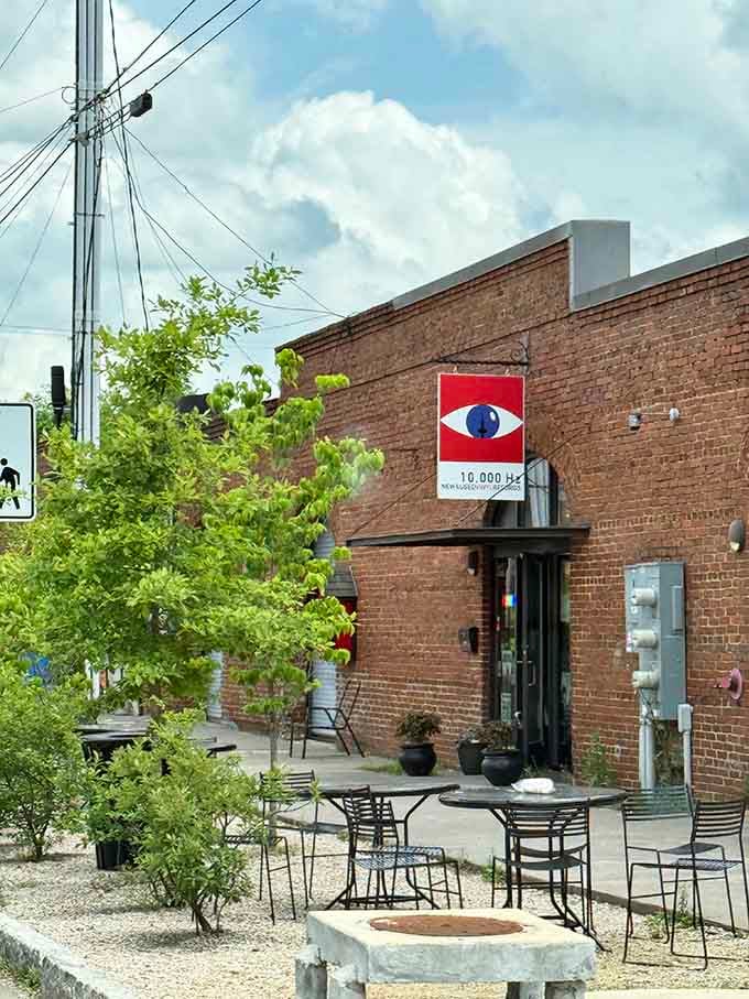 That eye-catching sign against weathered brick creates visual harmony, like finding the perfect B-side on a forgotten single.