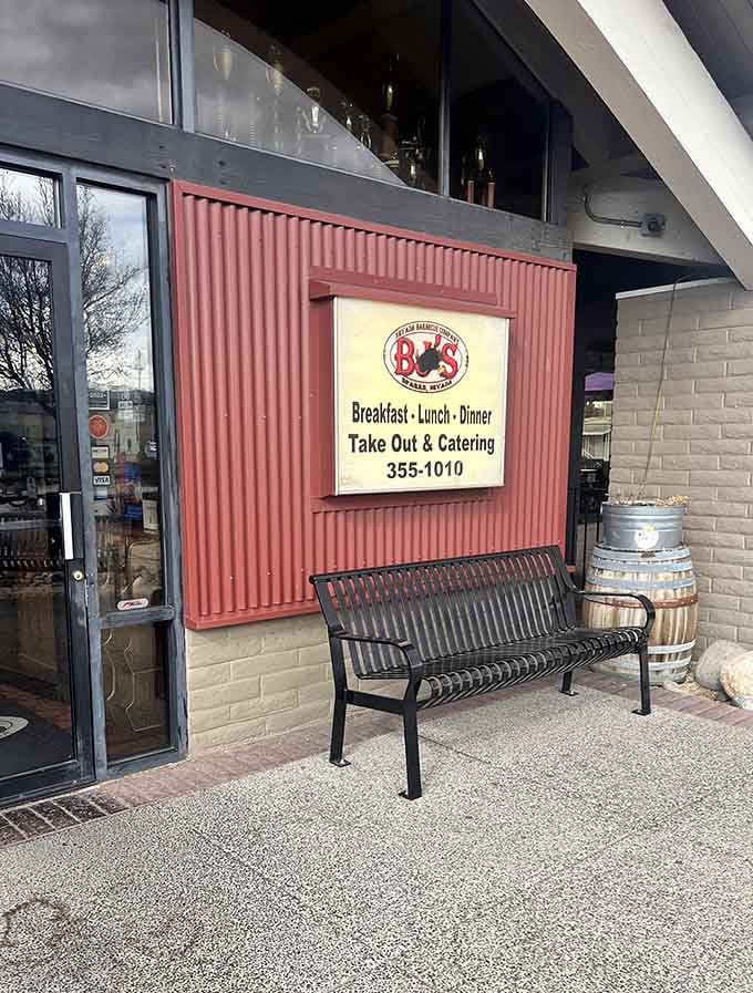 The rustic red exterior and simple bench say it all - this place cares more about smoking meat than impressing architects!