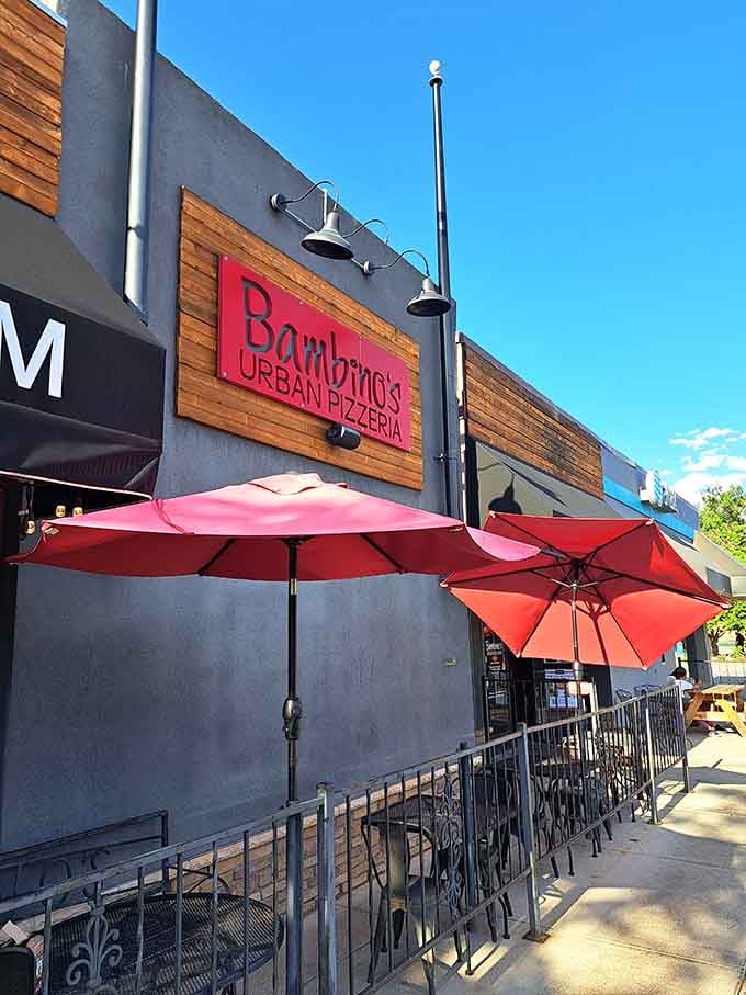 Modern meets delicious where red umbrellas promise shade and exceptional pizza delivers pure sunshine.
