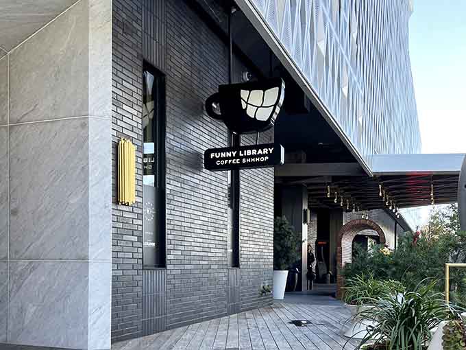 That smiling coffee cup sign beckons book lovers and caffeine enthusiasts to a cozy literary escape with stellar brews.