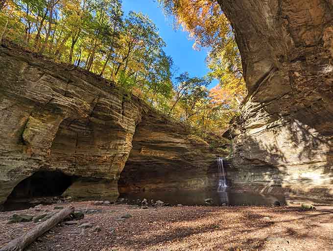 Layered limestone walls embrace a delicate waterfall in this hidden canyon that feels like discovering Narnia's secret entrance.