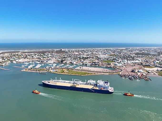 Where the Gulf meets industry in perfect harmony, massive ships glide through turquoise waters like floating cities.