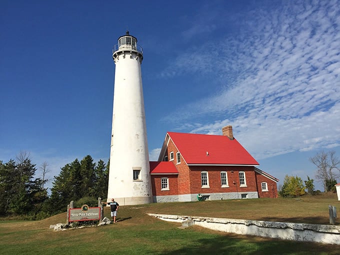 That red roof against white walls makes this lighthouse look like a postcard that somehow became three-dimensional and real.