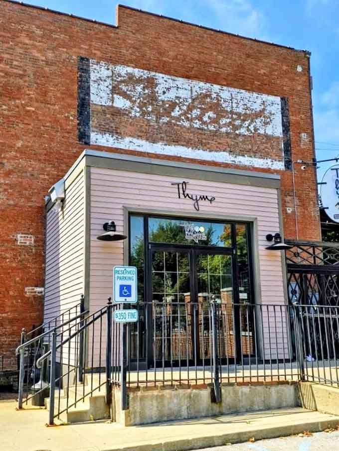 Modern elegance meets downtown charm where that weathered ghost sign above tells stories the sleek entrance is just beginning.