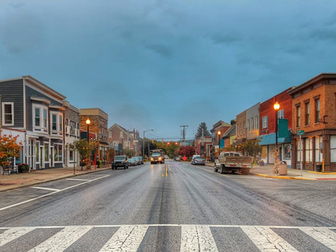 Rain-kissed streets and glowing streetlamps create a Norman Rockwell moment in this timeless downtown at dusk.