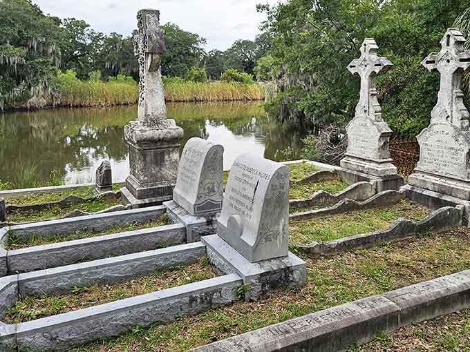 Waterside graves reflect in still waters, doubling the haunting beauty of this historic resting place by the lagoon.