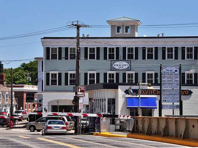 That classic white building with black shutters has watched generations pass by, still standing proud above the bustling street.