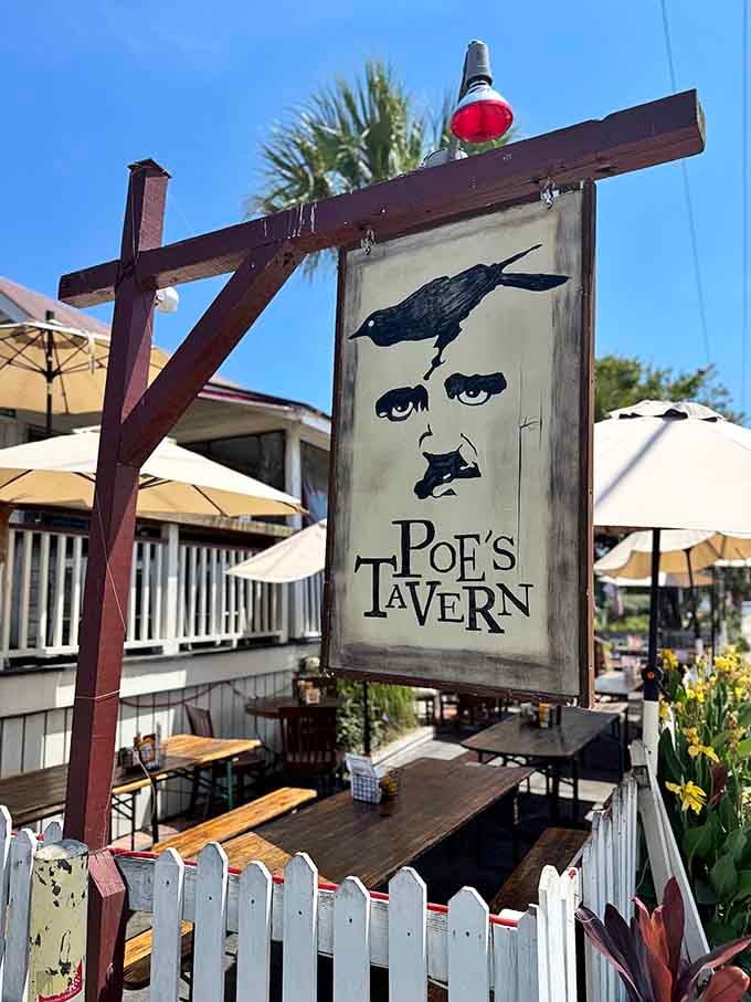 Edgar Allan Poe's mysterious silhouette watches over picnic tables where literary lovers gather for burgers and ocean breezes.