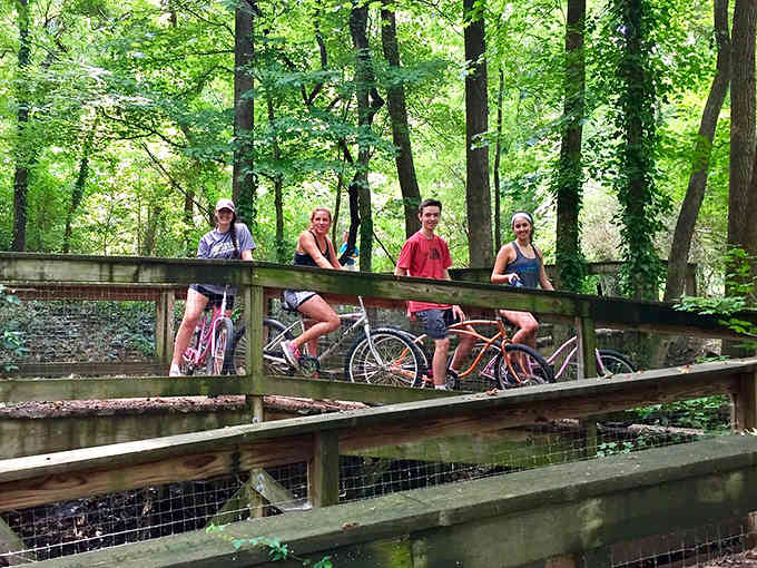 Families on bikes pause here like characters from a heartwarming summer movie scene.