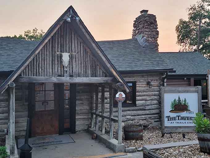 Golden hour light bathes the rustic logs and welcoming entrance, making this lakeside tavern glow like a warm memory waiting to happen.
