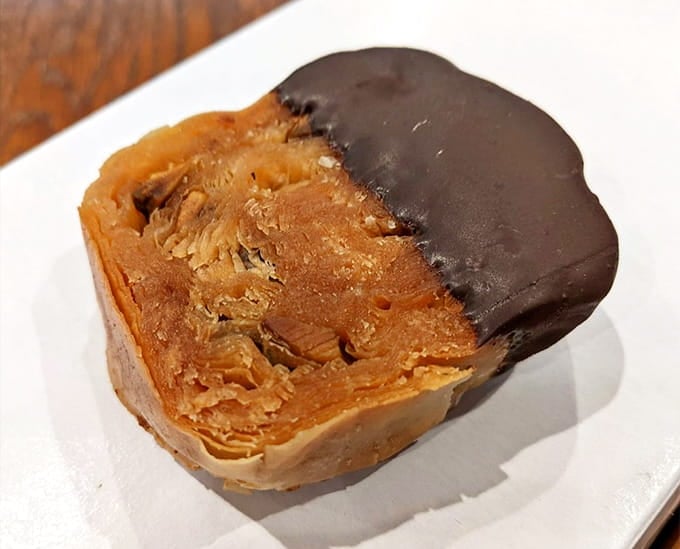 Layers of flaky phyllo dough meet honey and nuts in this chocolate-dipped masterpiece of Mediterranean engineering.