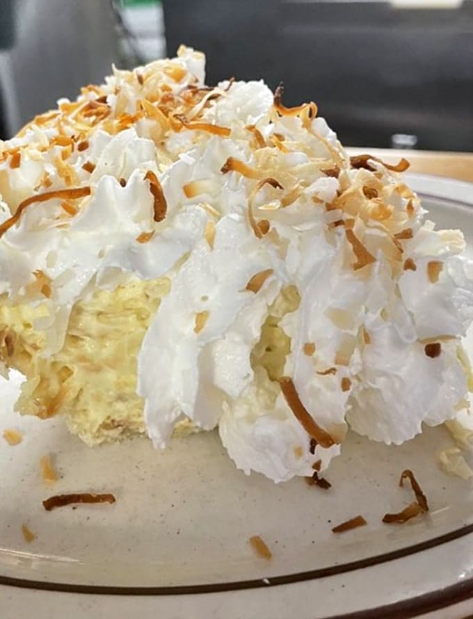 Toasted coconut crowns this cream pie like nature's confetti, making every forkful a tropical vacation for your taste buds.